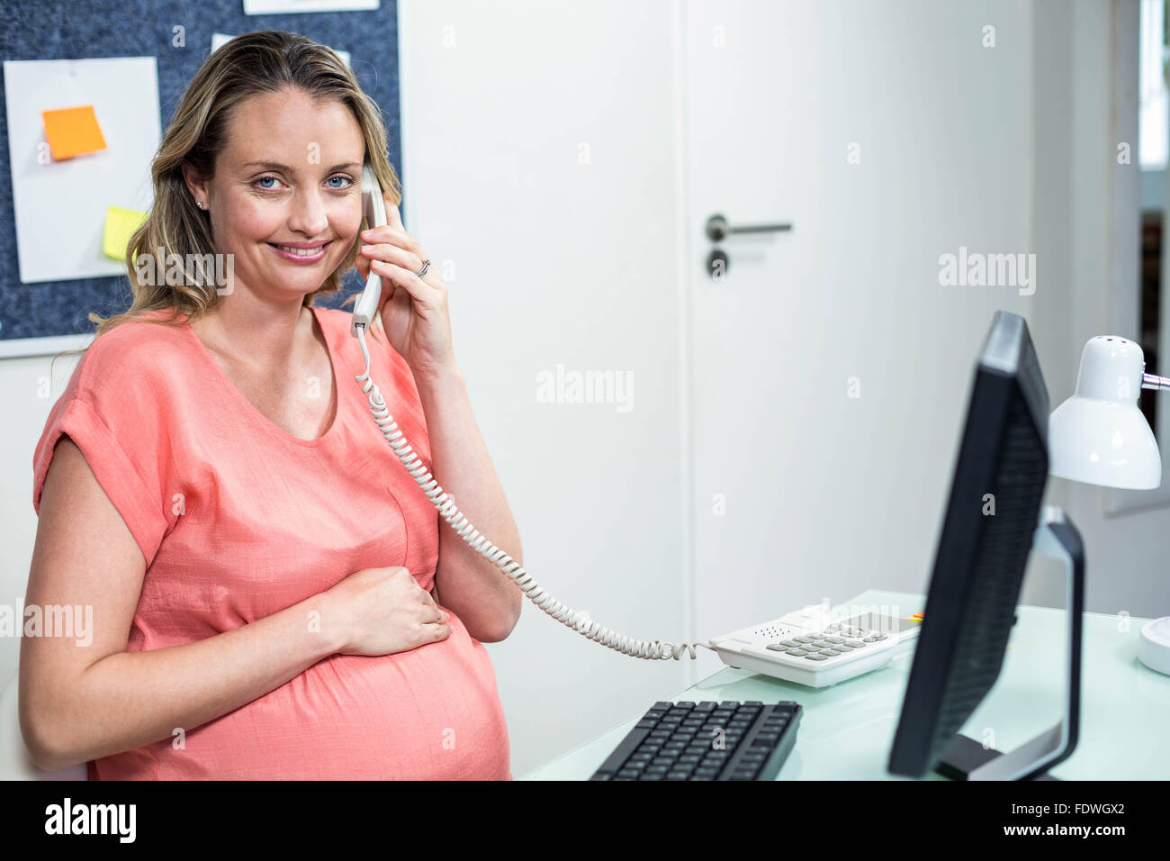 Pregnant woman using computer and phone Stock Photo - Alamy