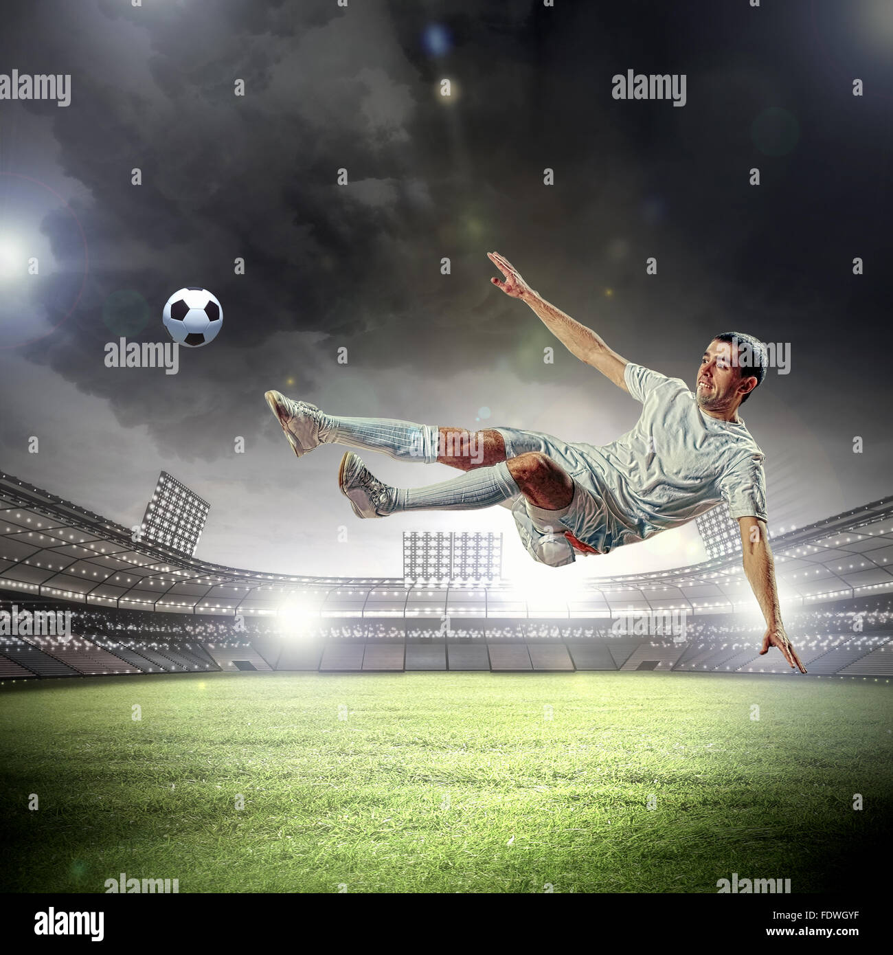 football player in white shirt striking the ball at the stadium Stock ...