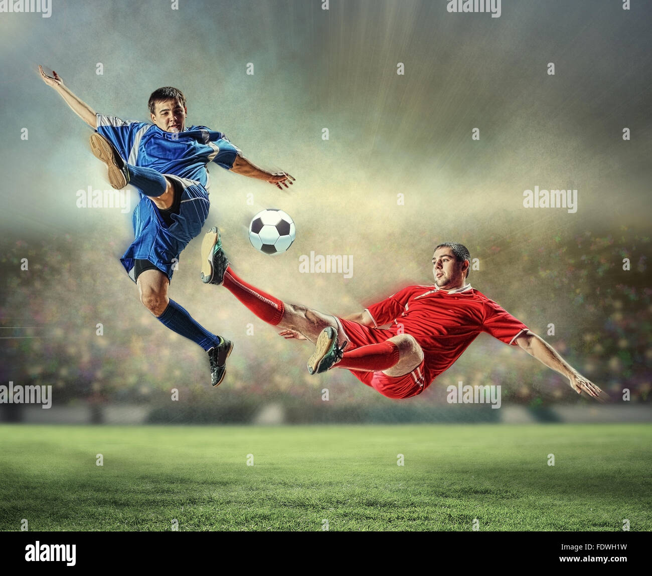two football players in jump to strike the ball at the stadium Stock ...