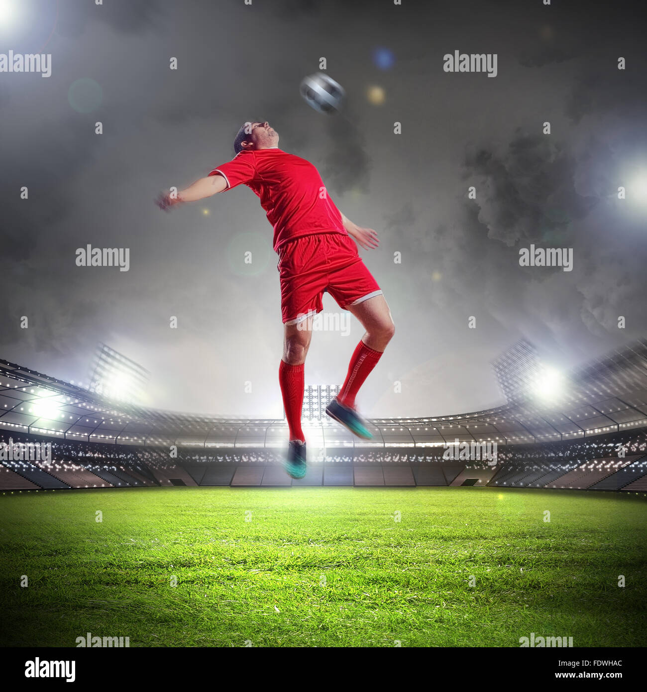 football player in red shirt striking the ball at the stadium Stock ...