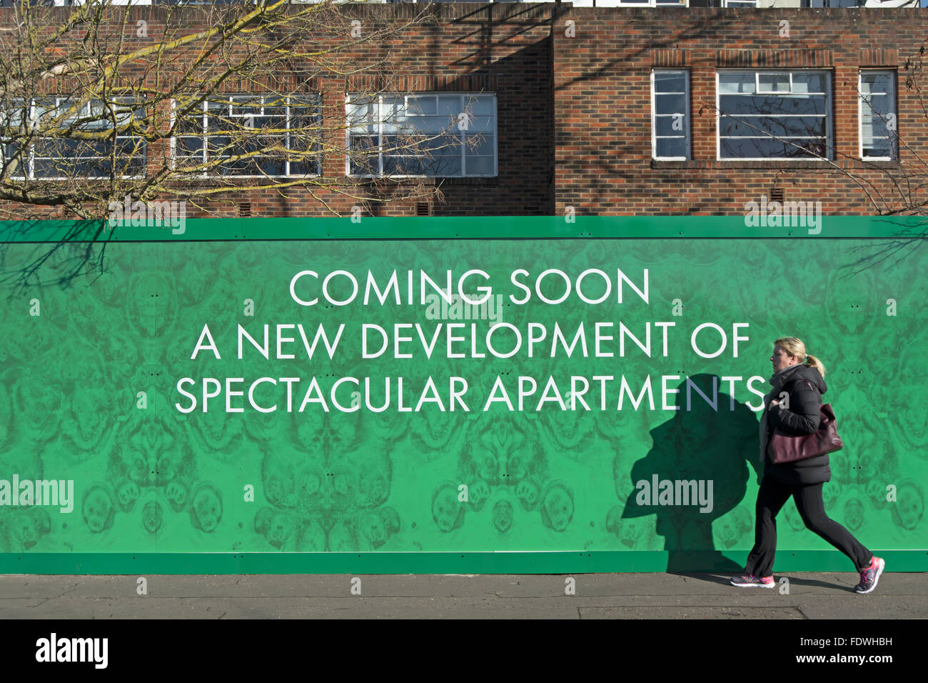 construction site fence advertising the spectacular new apartments of ...