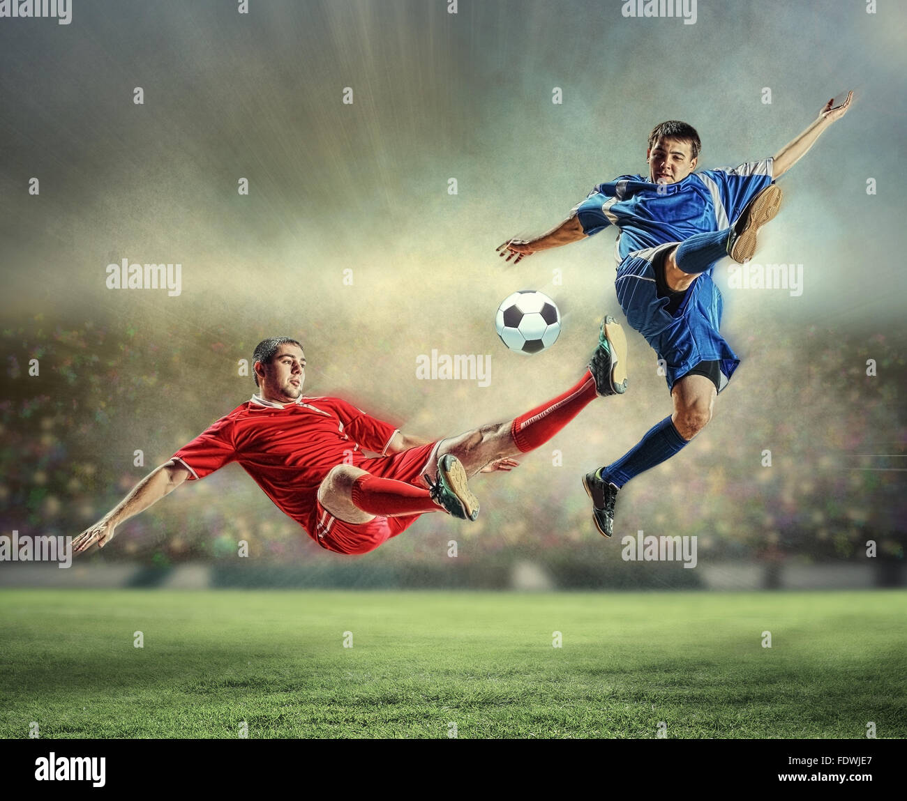 two football players in jump to strike the ball at the stadium Stock ...