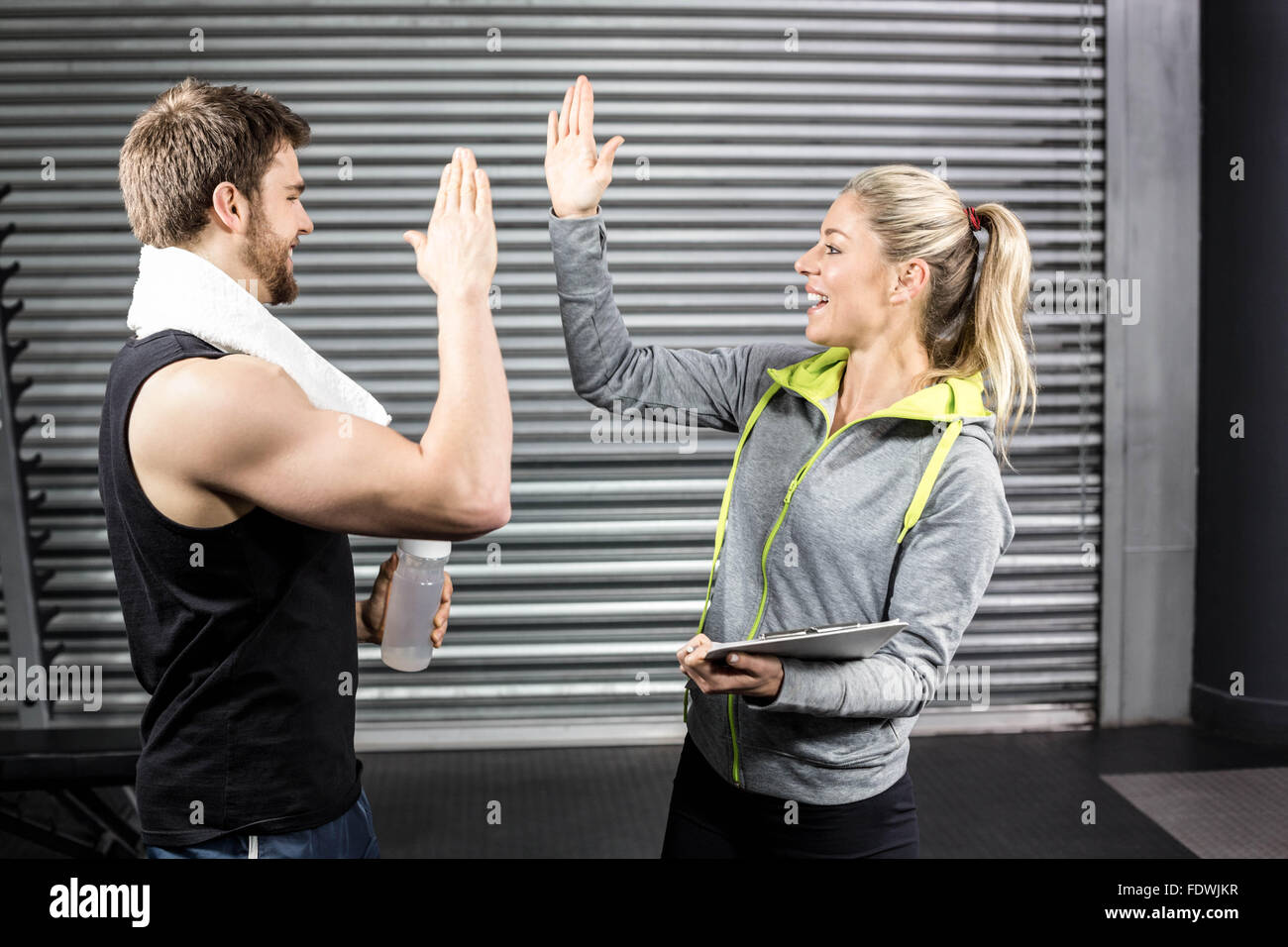 Fit couple high fiving in crossfit gym Stock Photo - Alamy