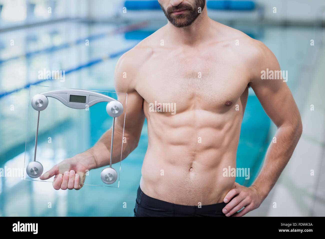 Fit man holding a weighting scale Stock Photo - Alamy