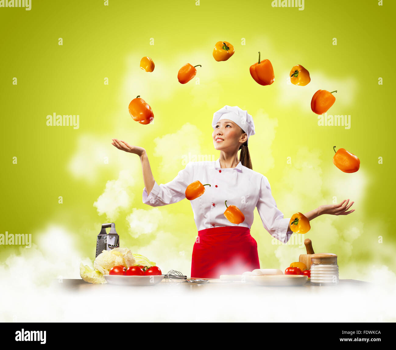 juggler female asian cook against color background Stock Photo - Alamy