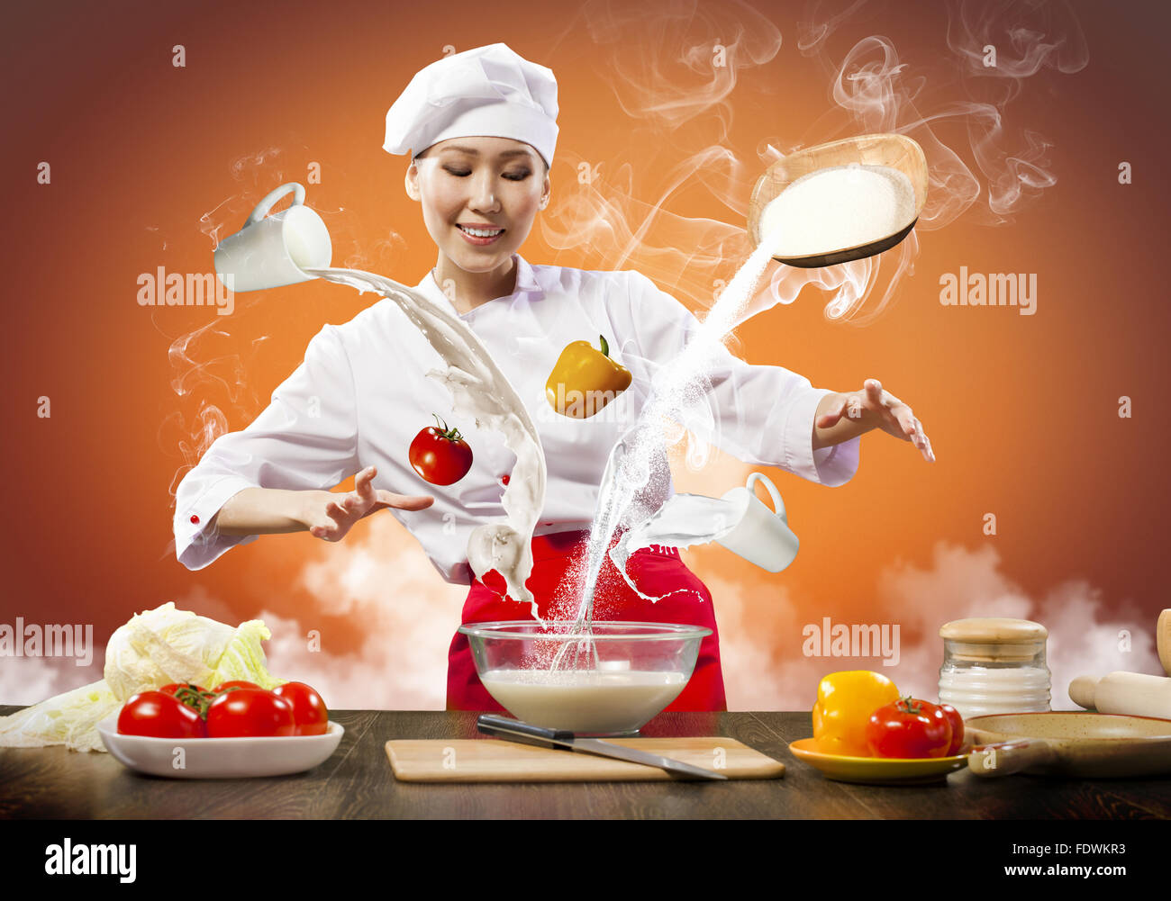 Asian female cooking with magic against color background Stock Photo ...