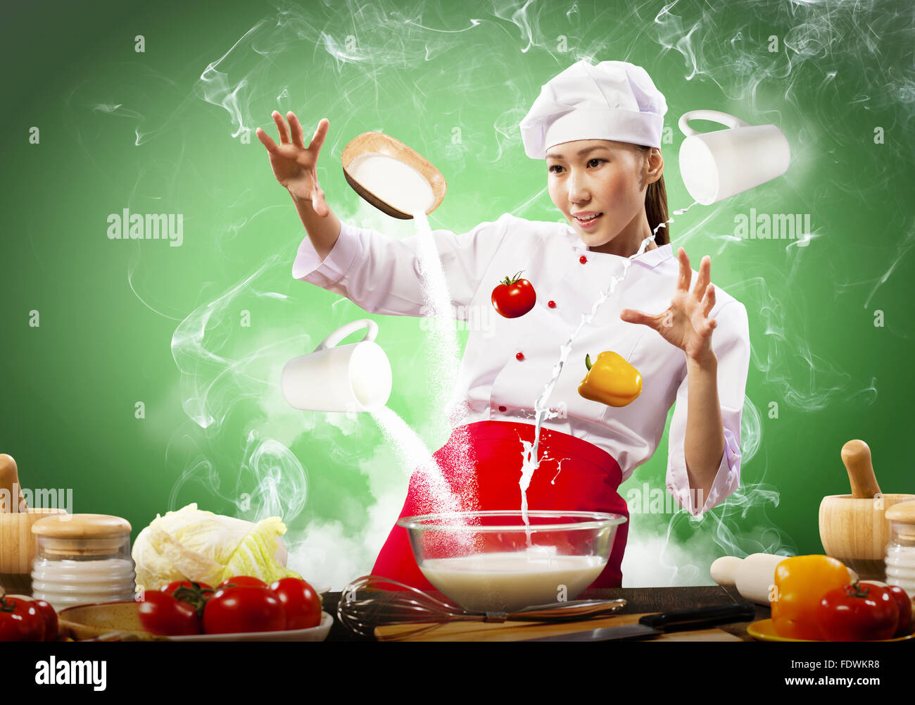 Asian female cooking with magic against color background Stock Photo ...