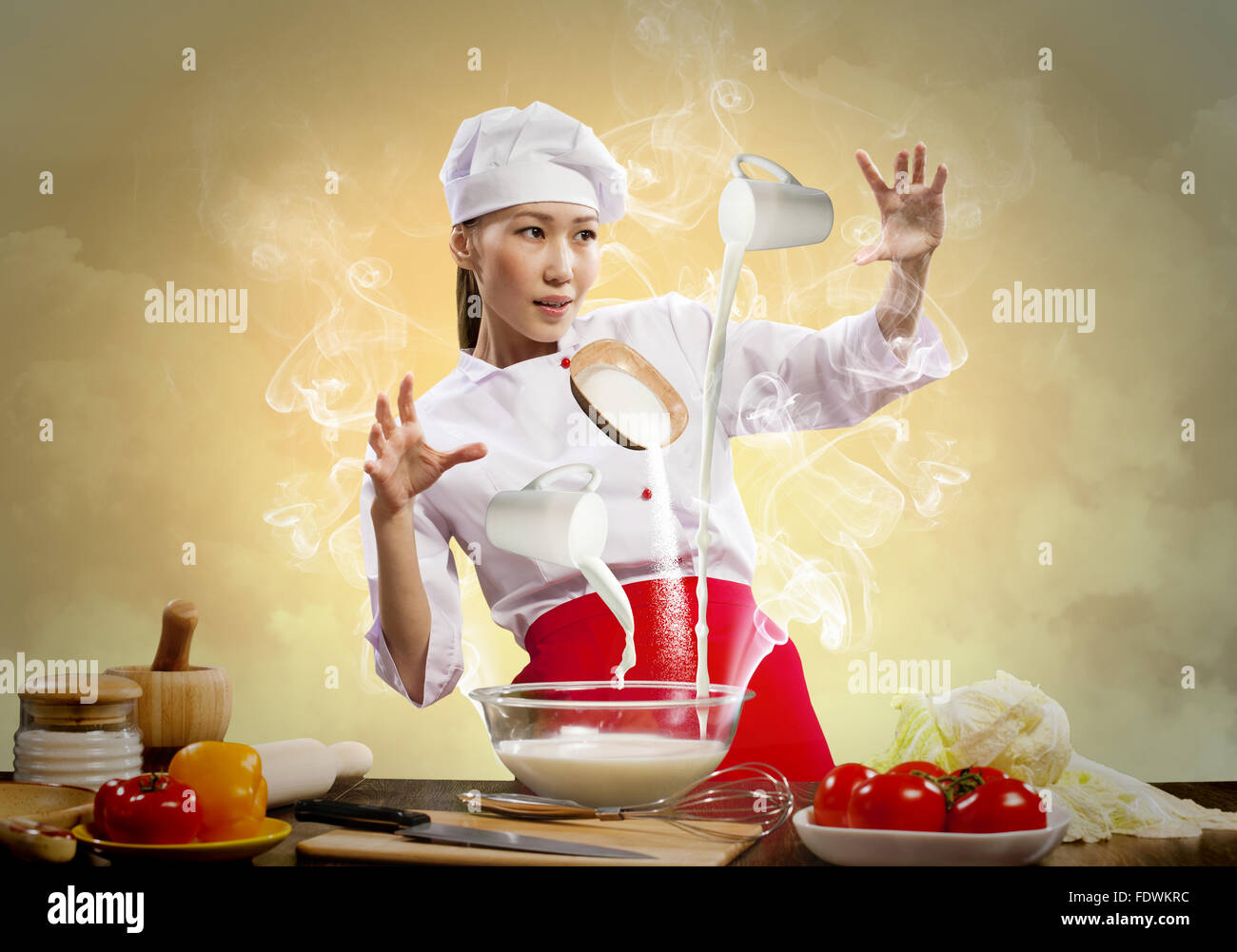 Asian female cooking with magic against color background Stock Photo ...