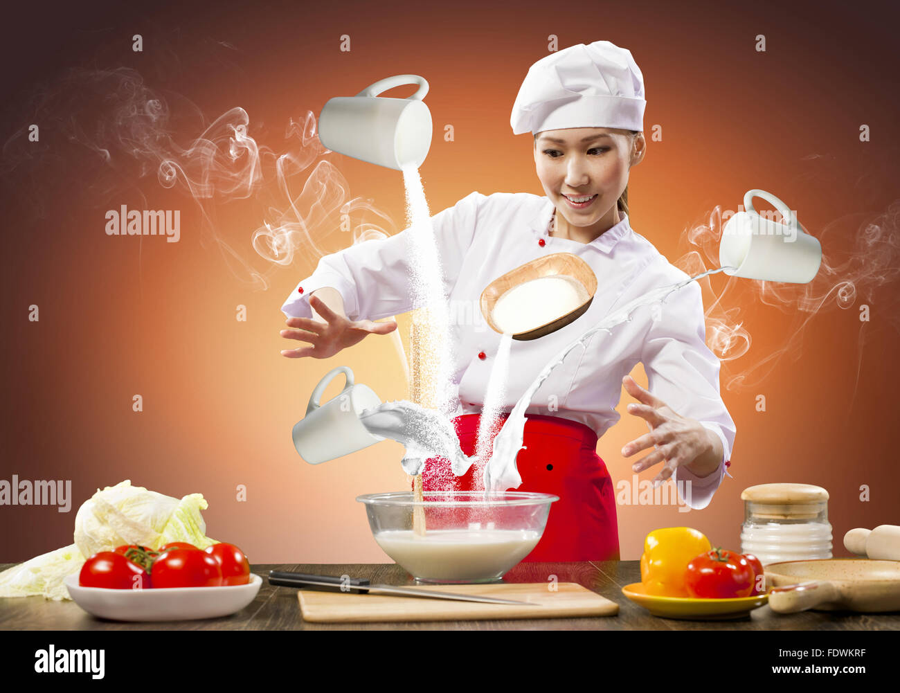Asian female cooking with magic against color background Stock Photo ...