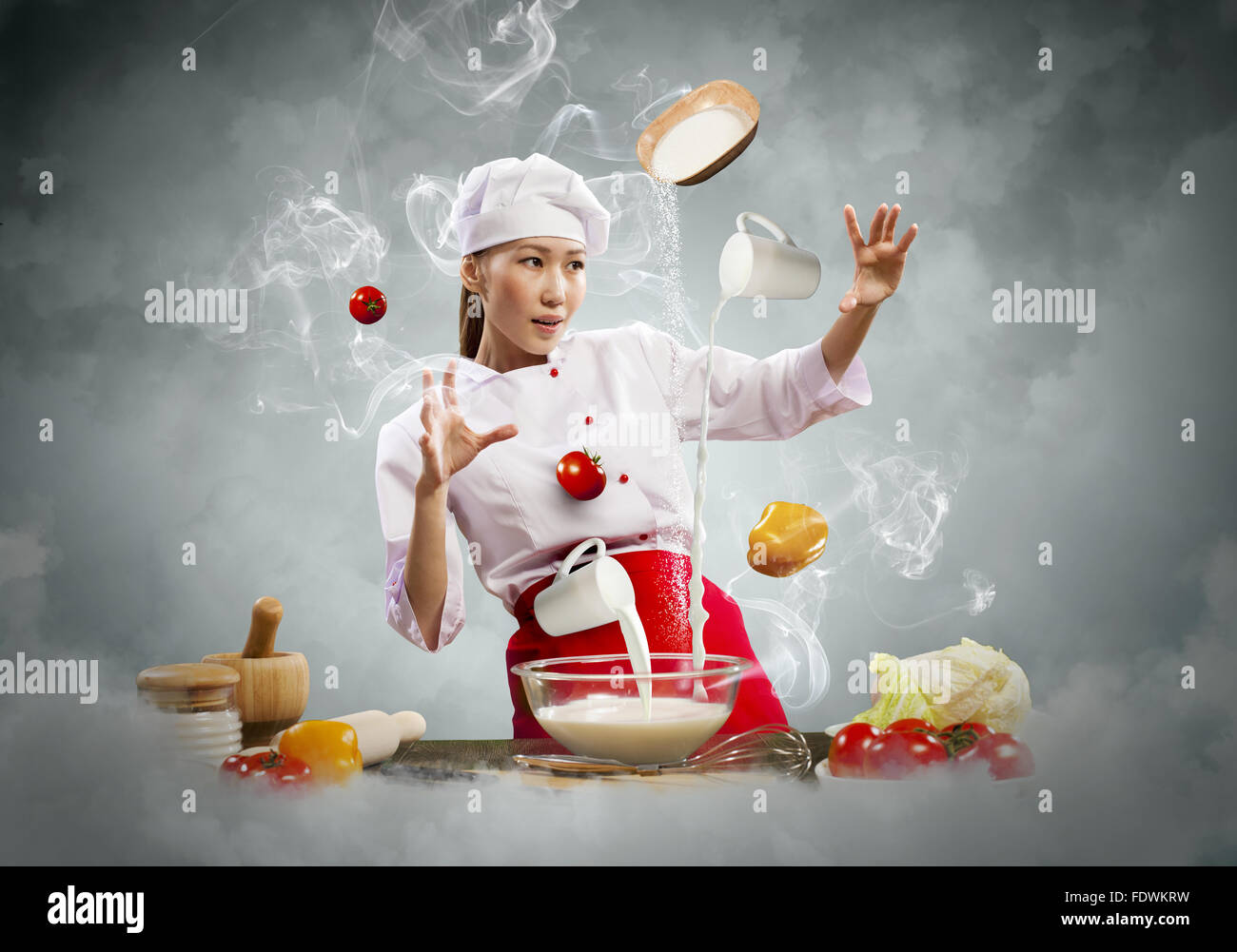 Asian female cooking with magic against color background Stock Photo ...