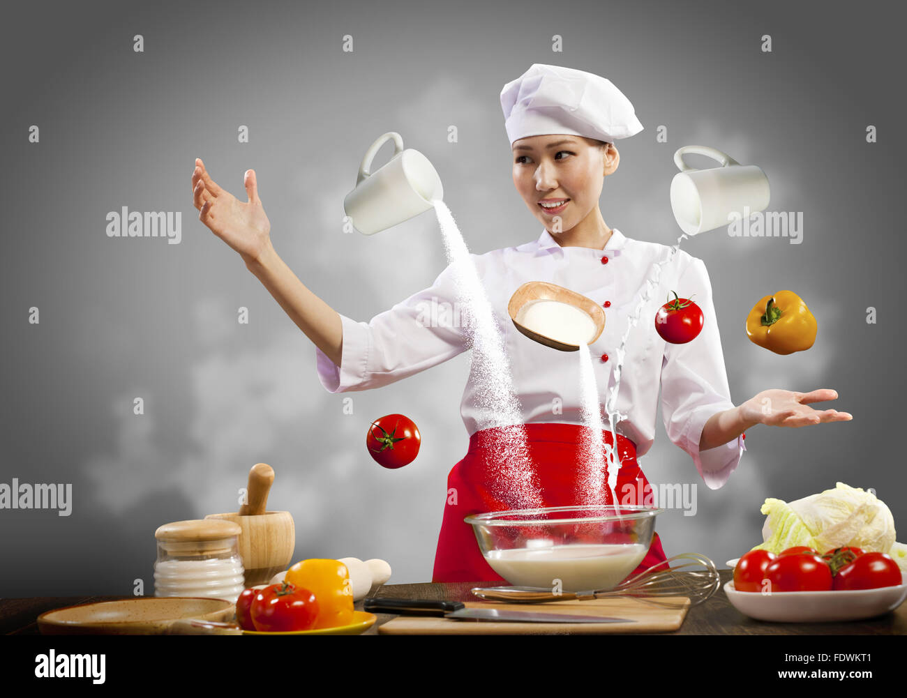 Asian female cooking with magic against color background Stock Photo ...