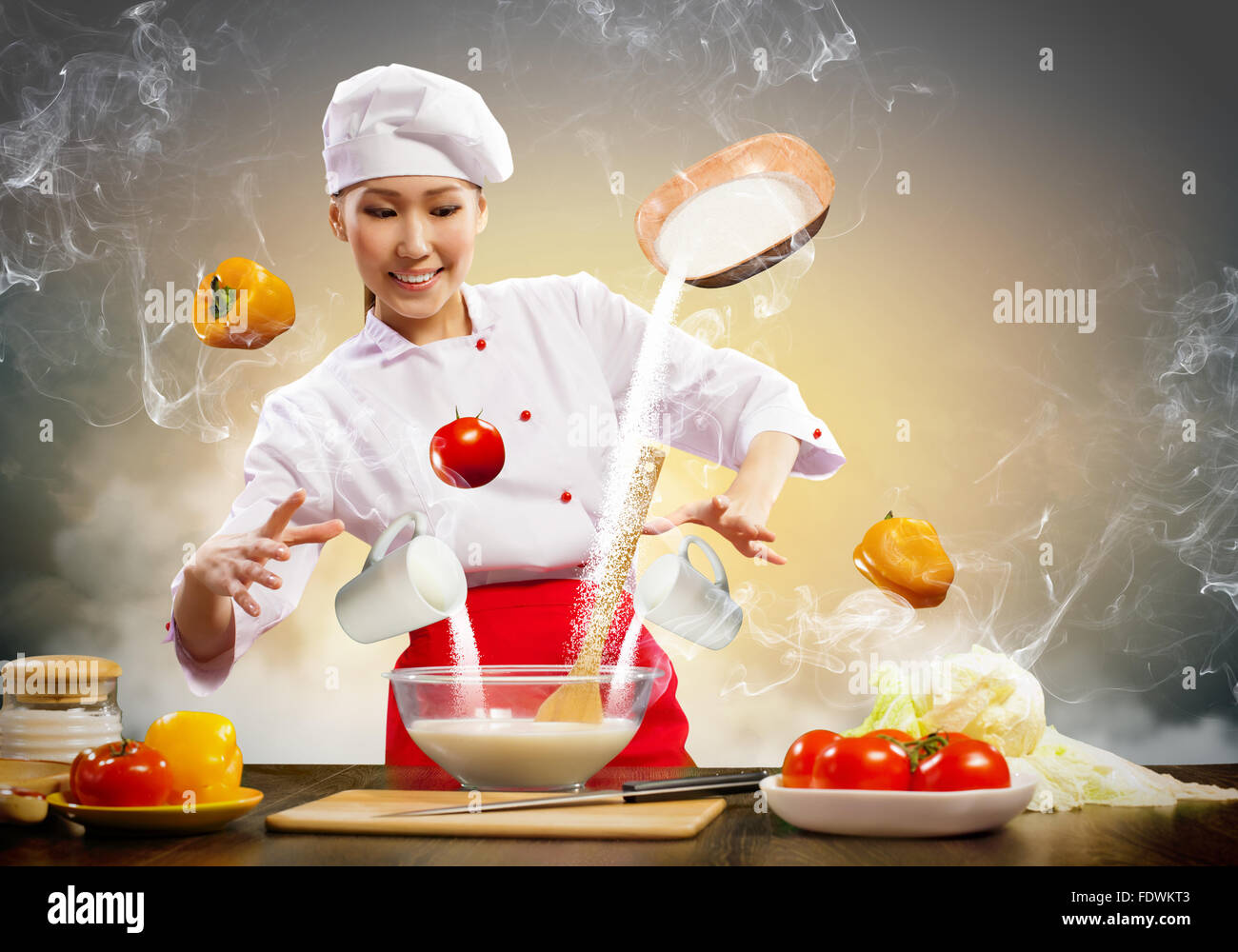 Asian female cooking with magic against color background Stock Photo ...
