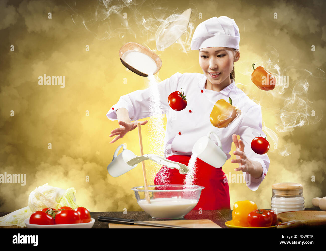 Asian female cooking with magic against color background Stock Photo ...