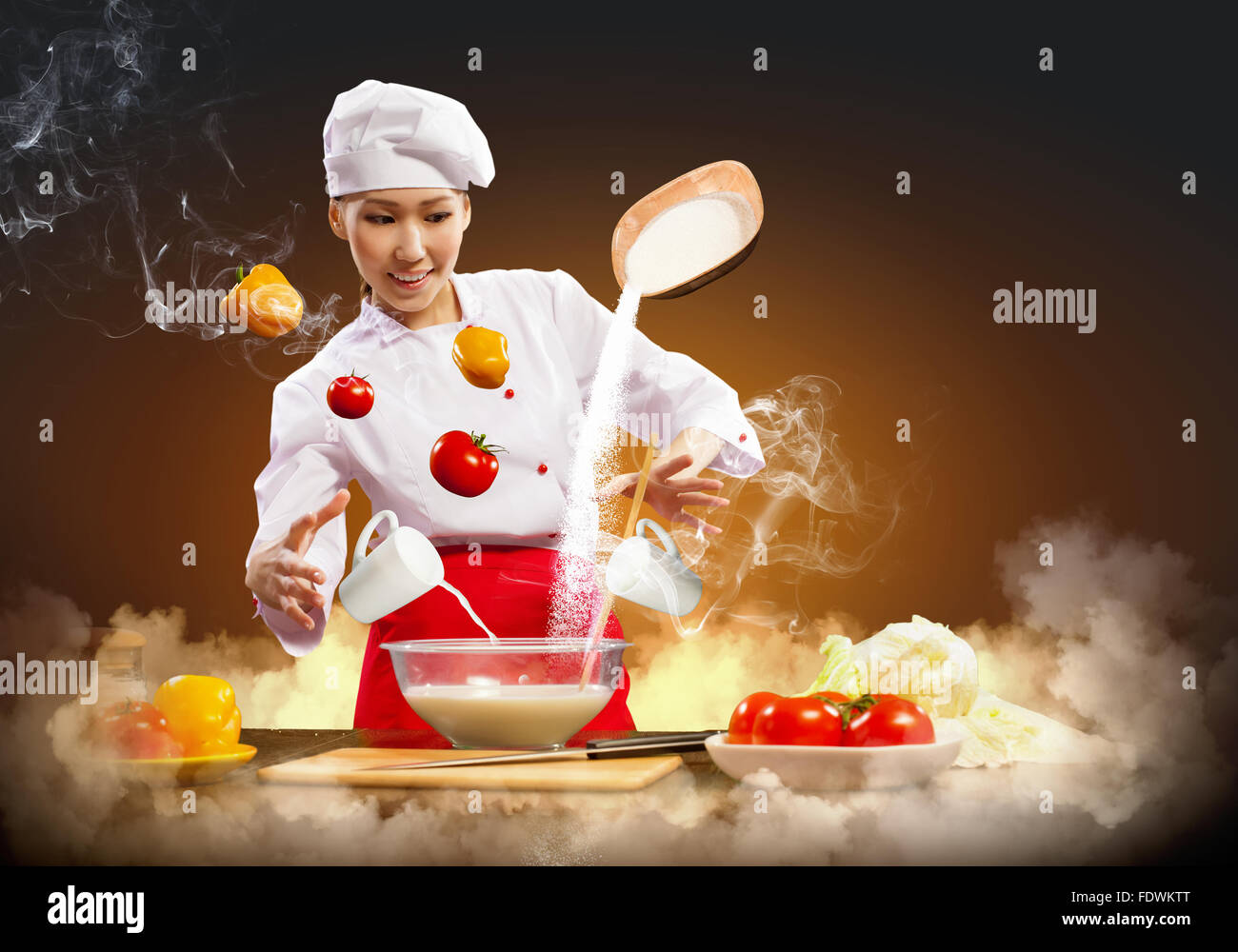 Asian female cooking with magic against color background Stock Photo ...