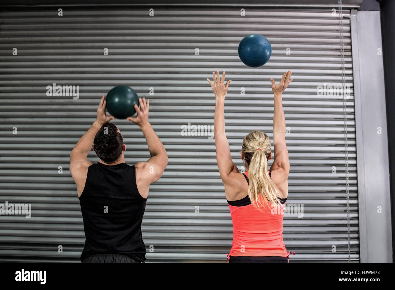 Couple throwing ball in the air Stock Photo - Alamy