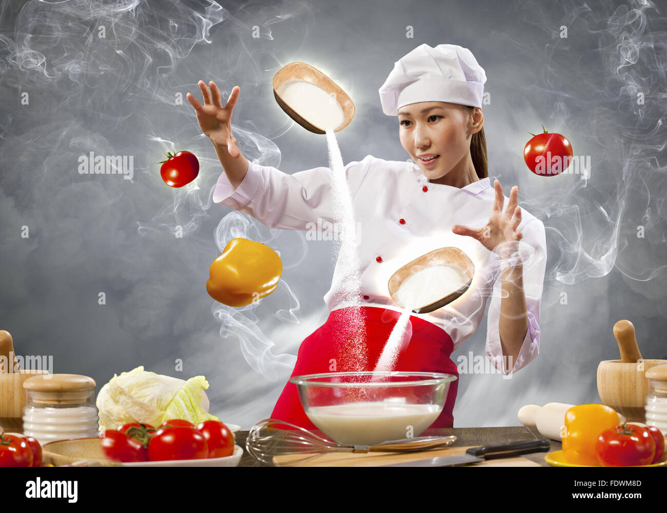 Asian female cooking with magic against color background Stock Photo ...