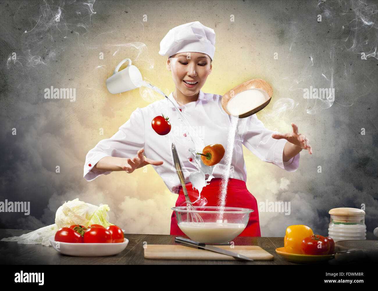 Asian female cooking with magic against color background Stock Photo ...