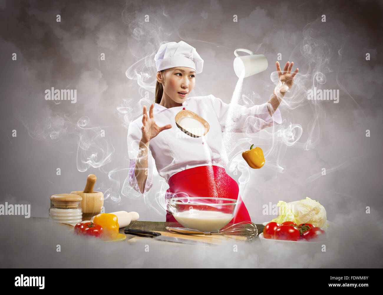 Asian female cooking with magic against color background Stock Photo ...