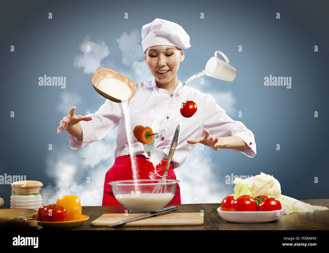Asian female cooking with magic against color background Stock Photo ...
