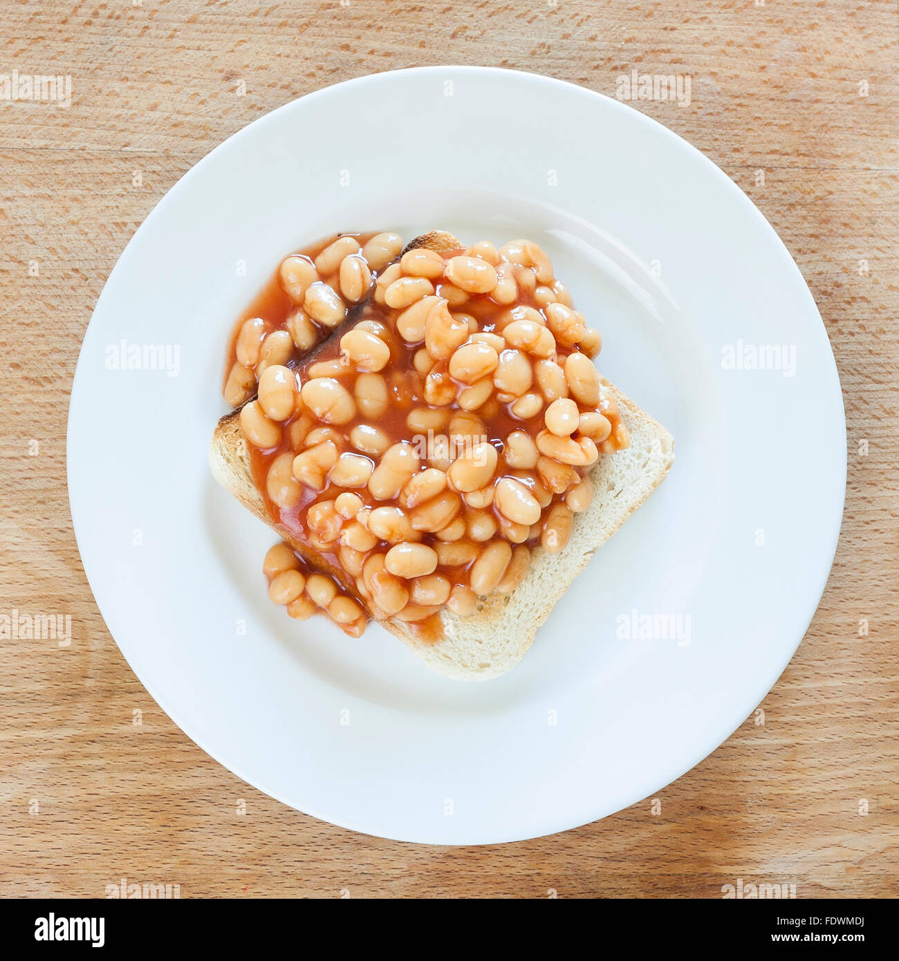 Beans on toast on a plate and wood background Model Release: No ...