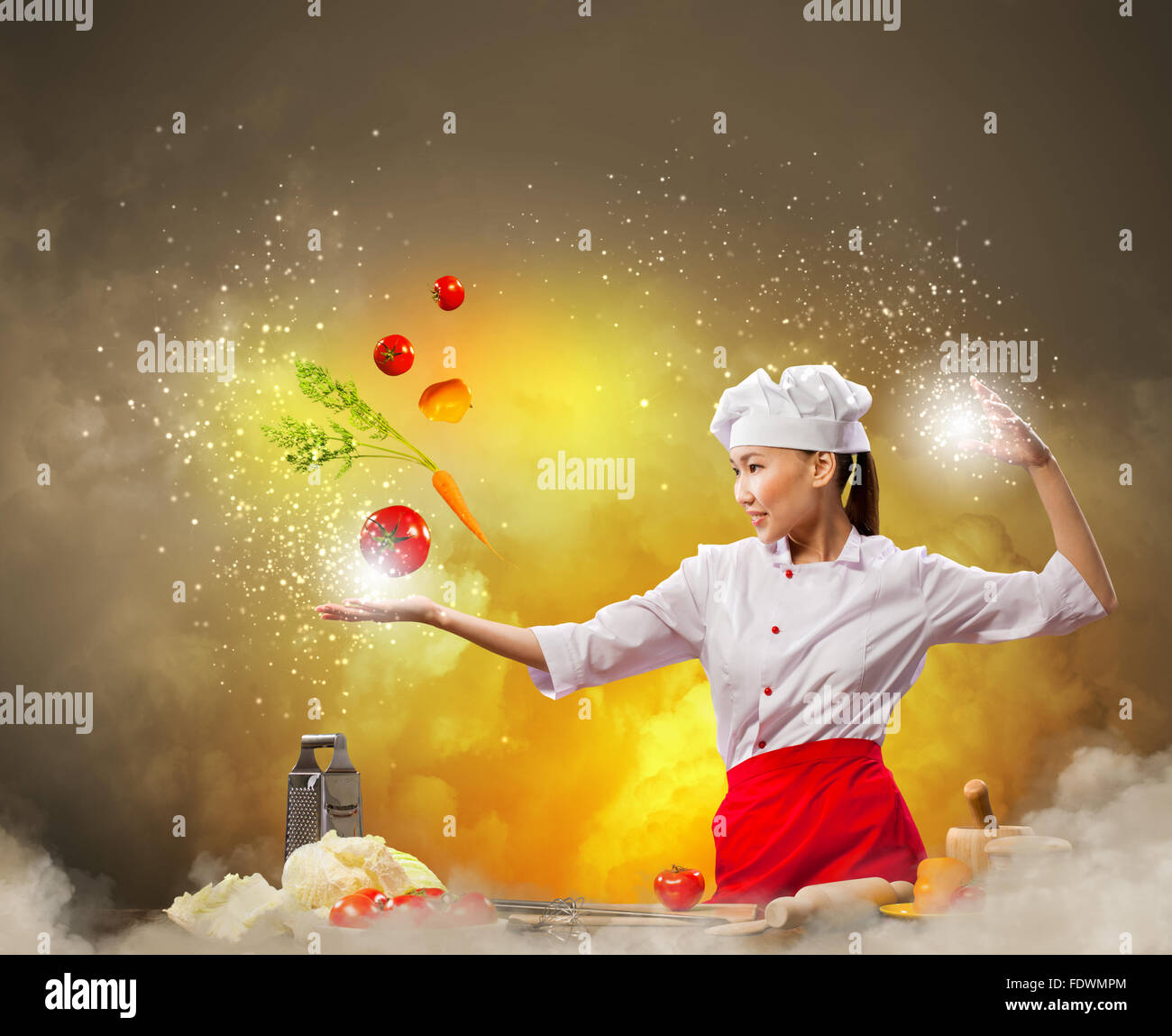 Asian female cooking with magic against color background Stock Photo ...