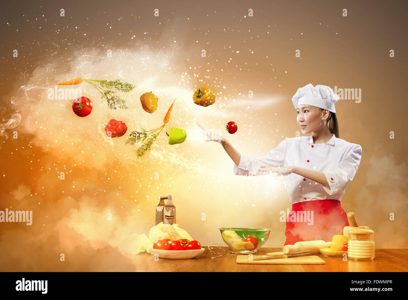 Asian female cooking with magic against color background Stock Photo ...