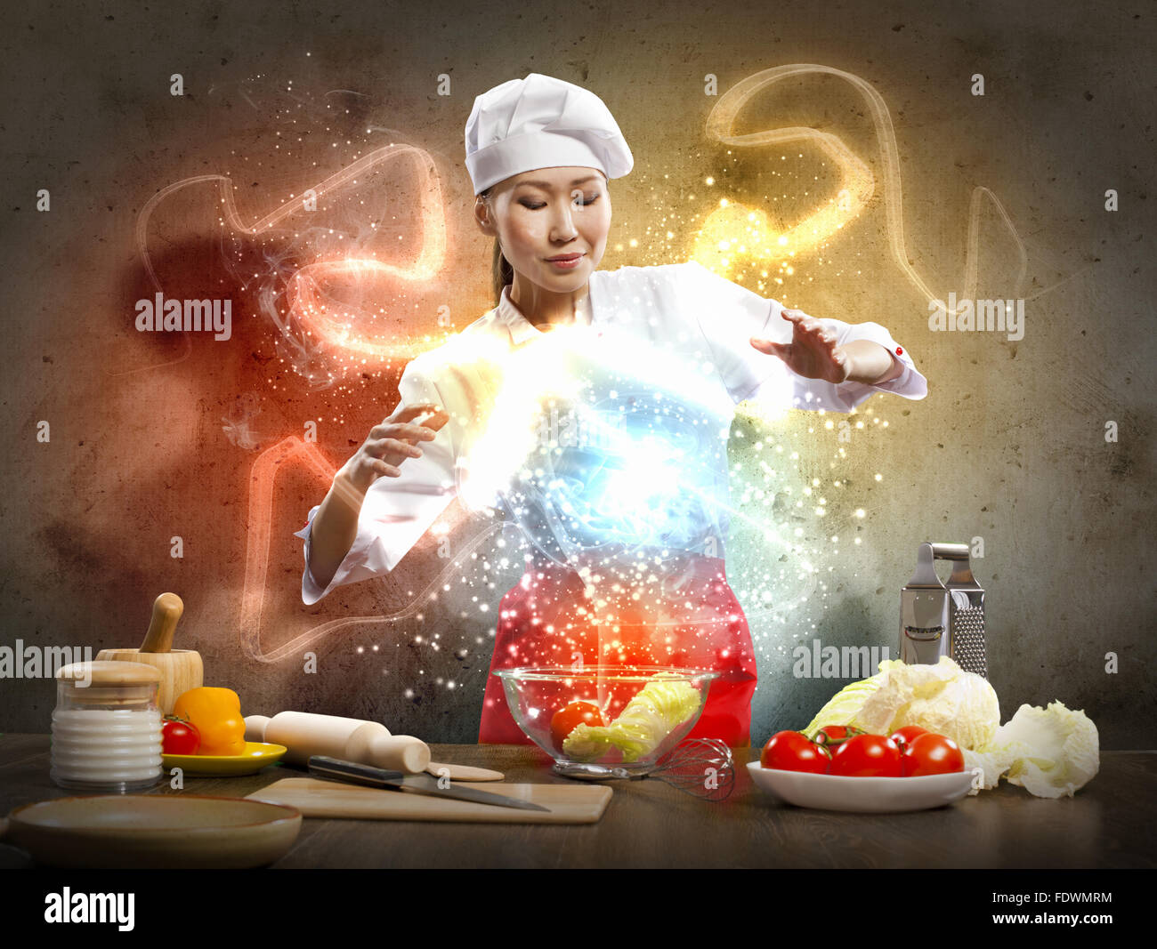 Asian female cooking with magic against color background Stock Photo ...