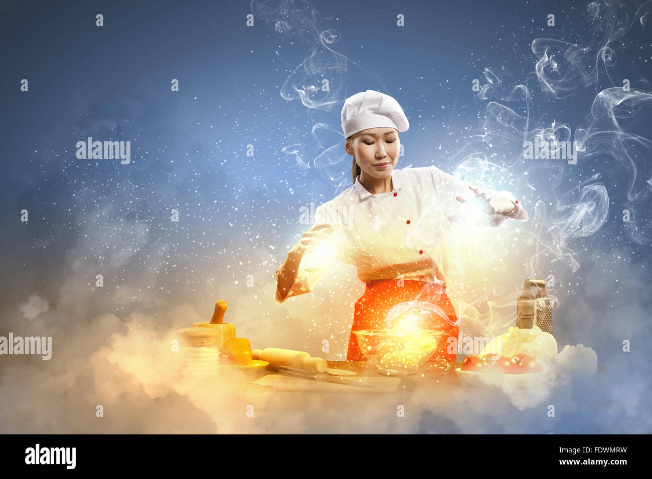 Asian female cooking with magic against color background Stock Photo ...