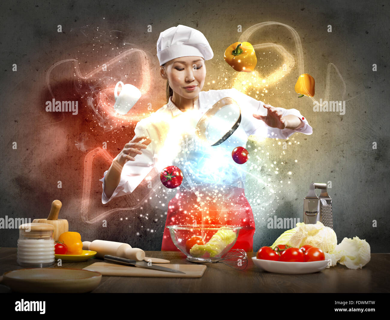 Asian female cooking with magic against color background Stock Photo ...