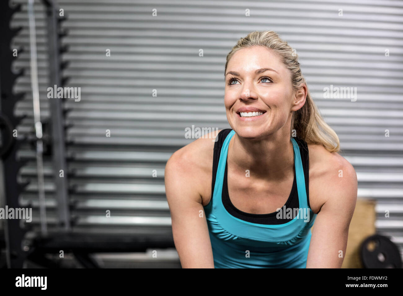 Smiling fit woman sitting Stock Photo - Alamy