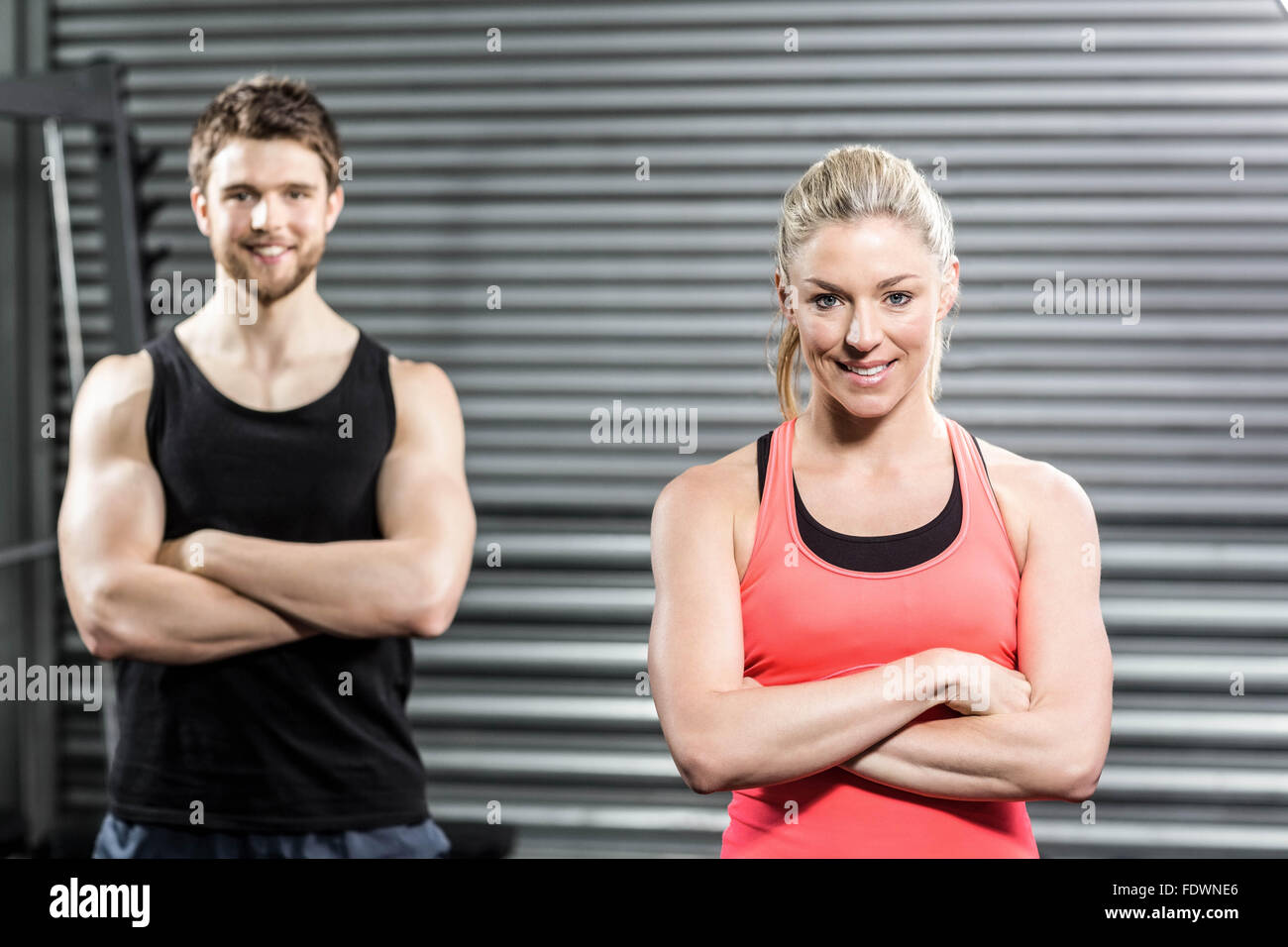 Fit couple with arm crossed Stock Photo - Alamy