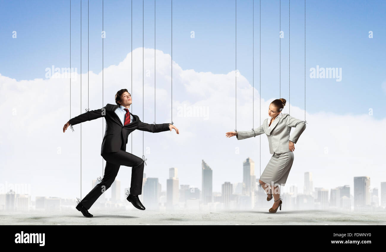 Image of businesspeople hanging on strings like marionettes against ...