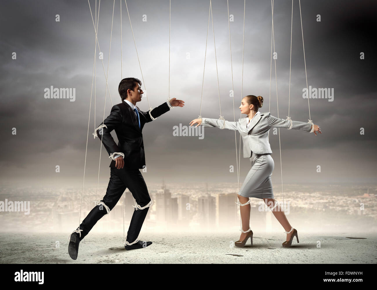 Image of businesspeople hanging on strings like marionettes against ...
