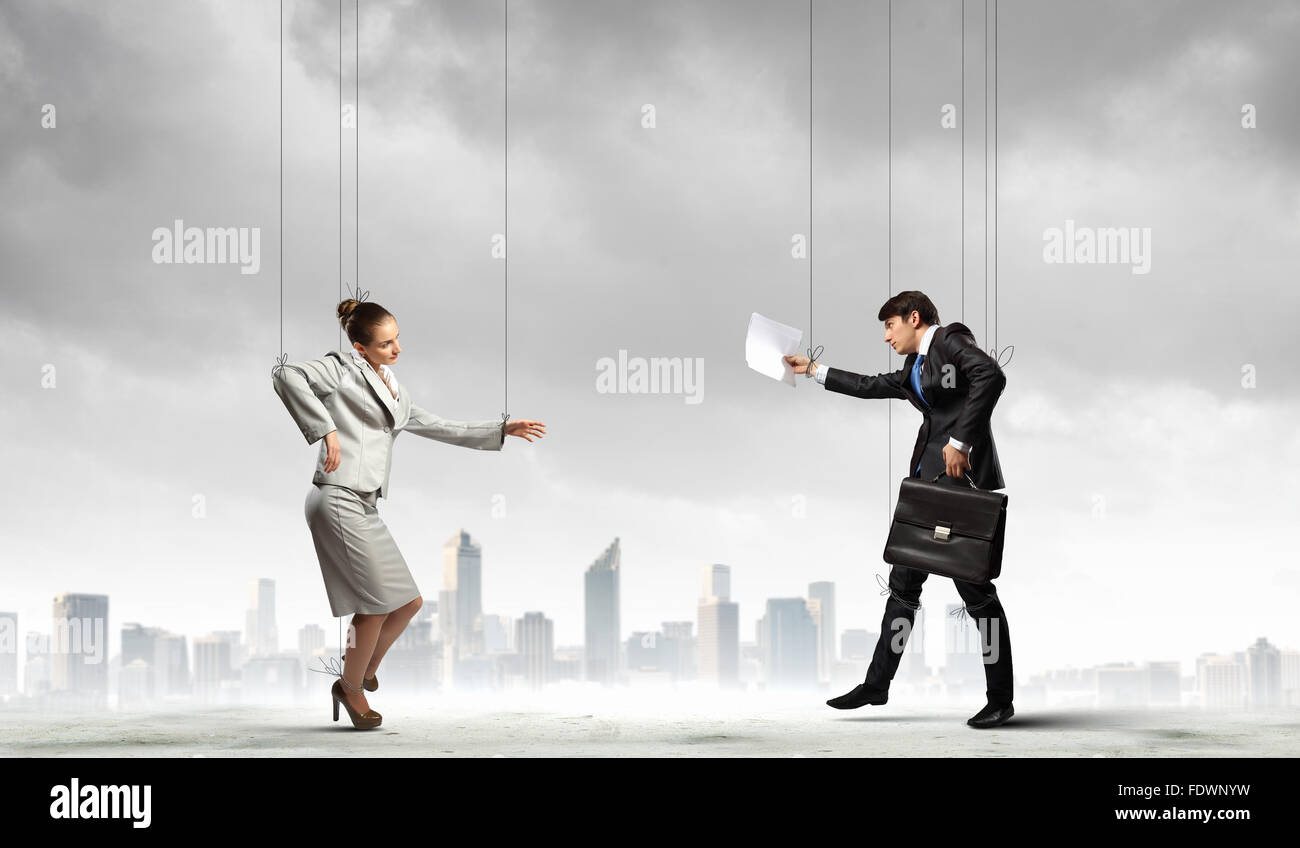 Image of businesspeople hanging on strings like marionettes against ...