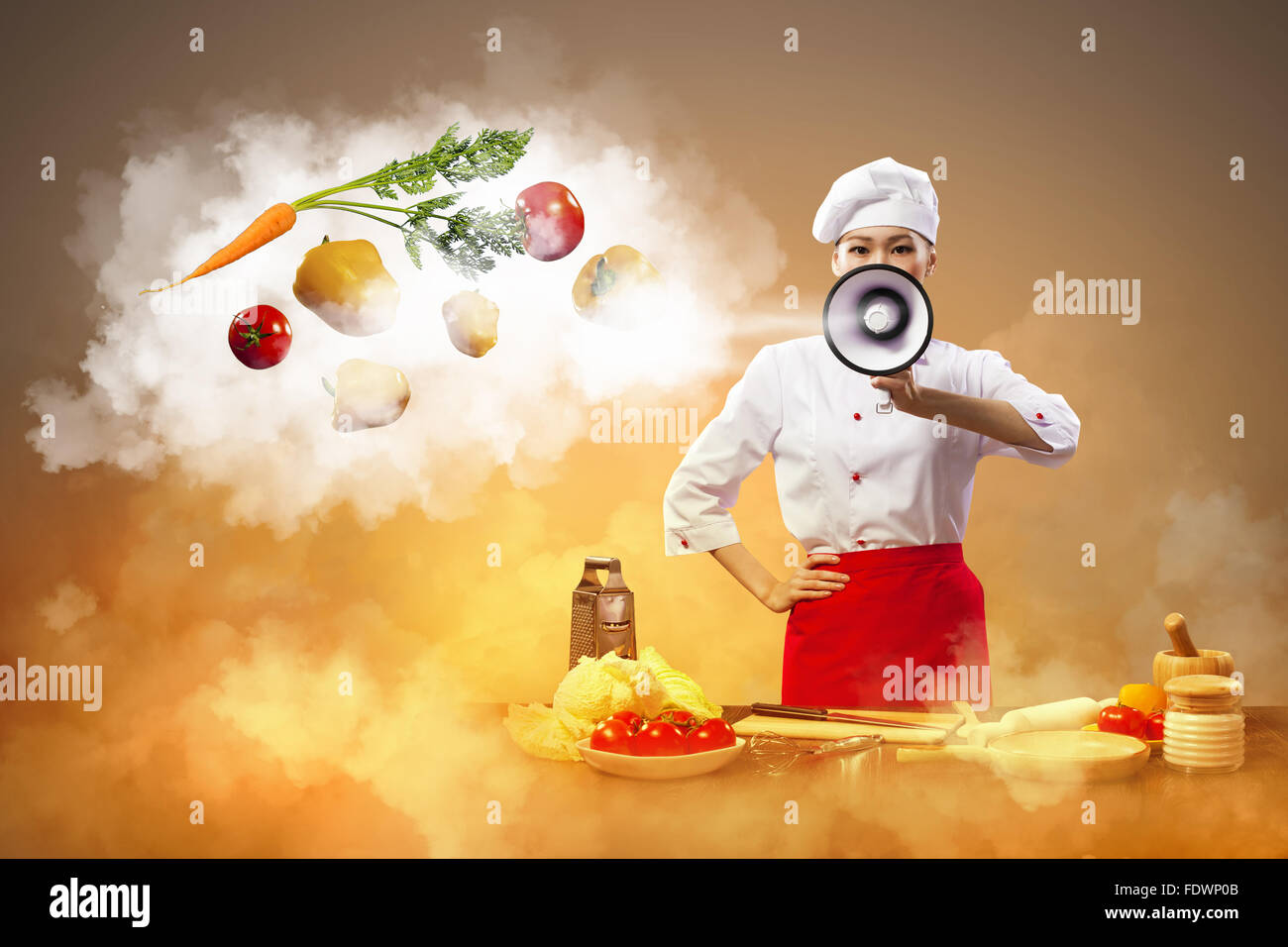 Asian female cook holding megaphone vegetables flying in air Stock ...