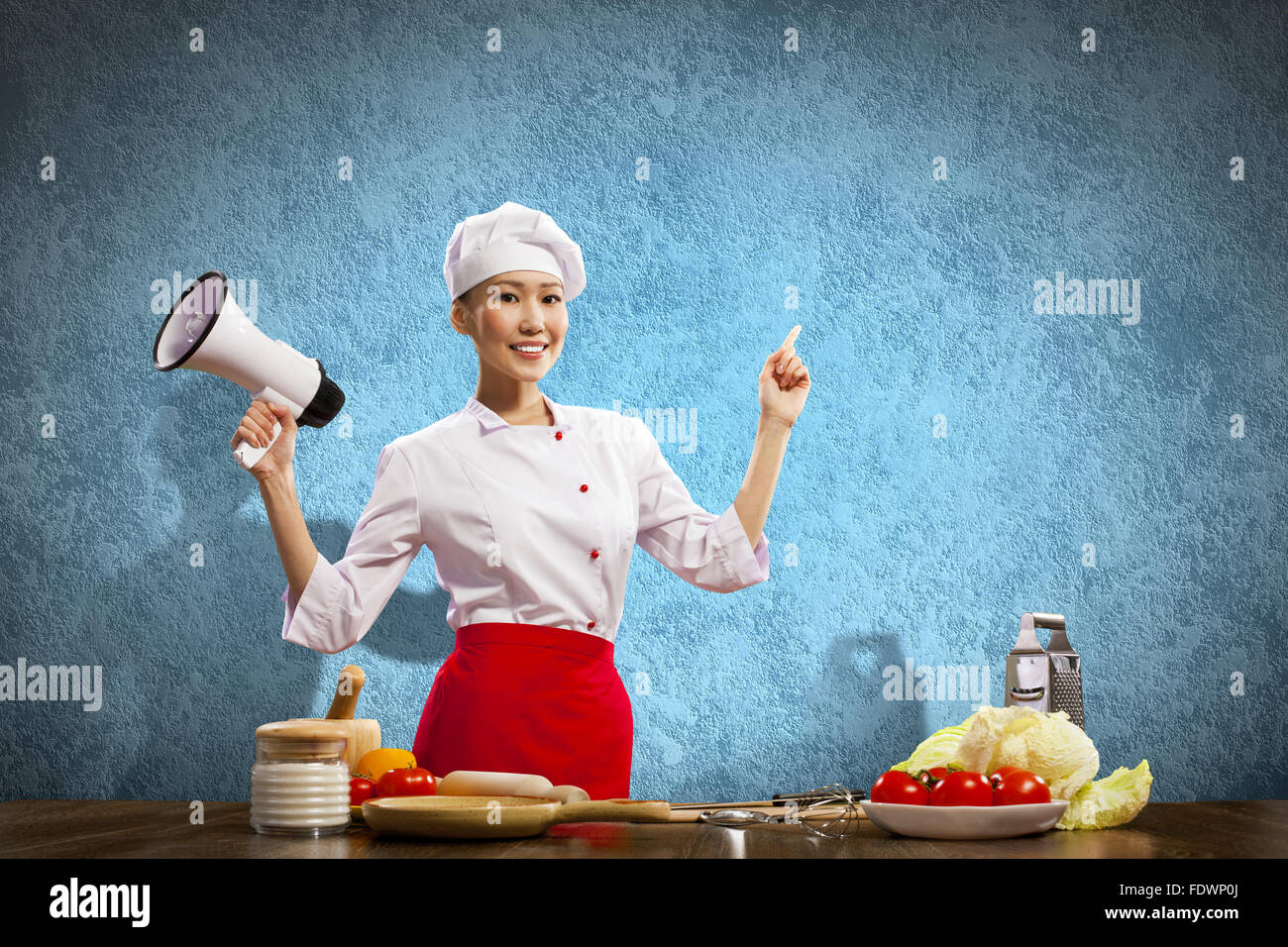 Asian female cook holding megaphone vegetables flying in air Stock ...