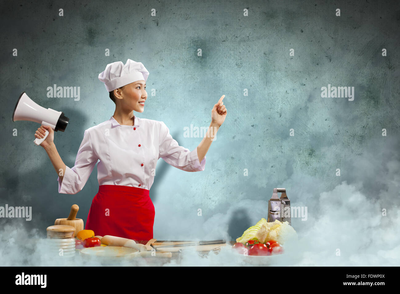 Asian female young cook smiling holding megaphone Stock Photo - Alamy