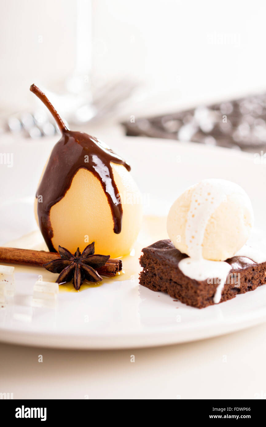 Plated dessert with poached pears, brownie and ice cream Stock Photo ...
