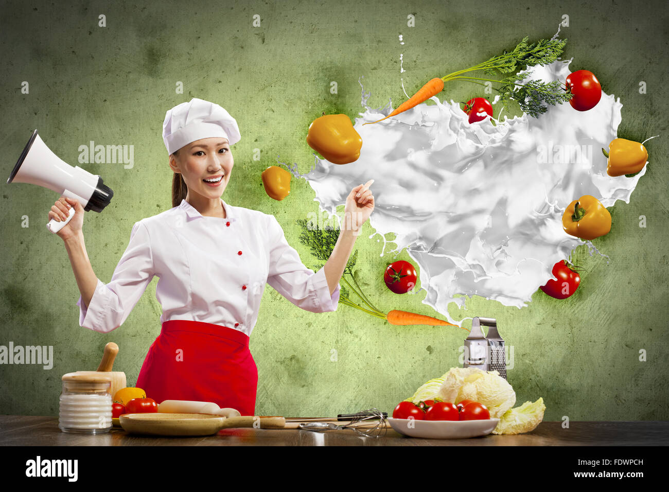 Asian female cook holding megaphone vegetables flying in air Stock ...