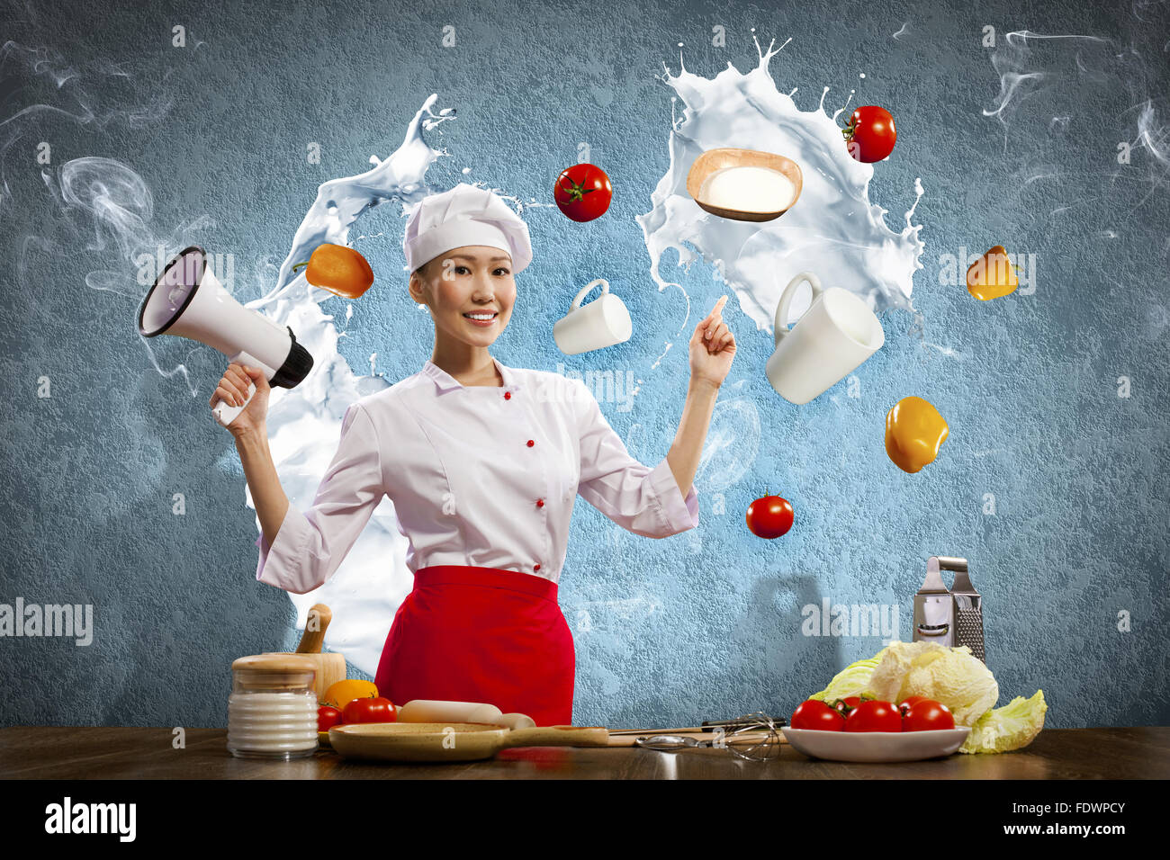 Asian female cook holding megaphone vegetables flying in air Stock ...