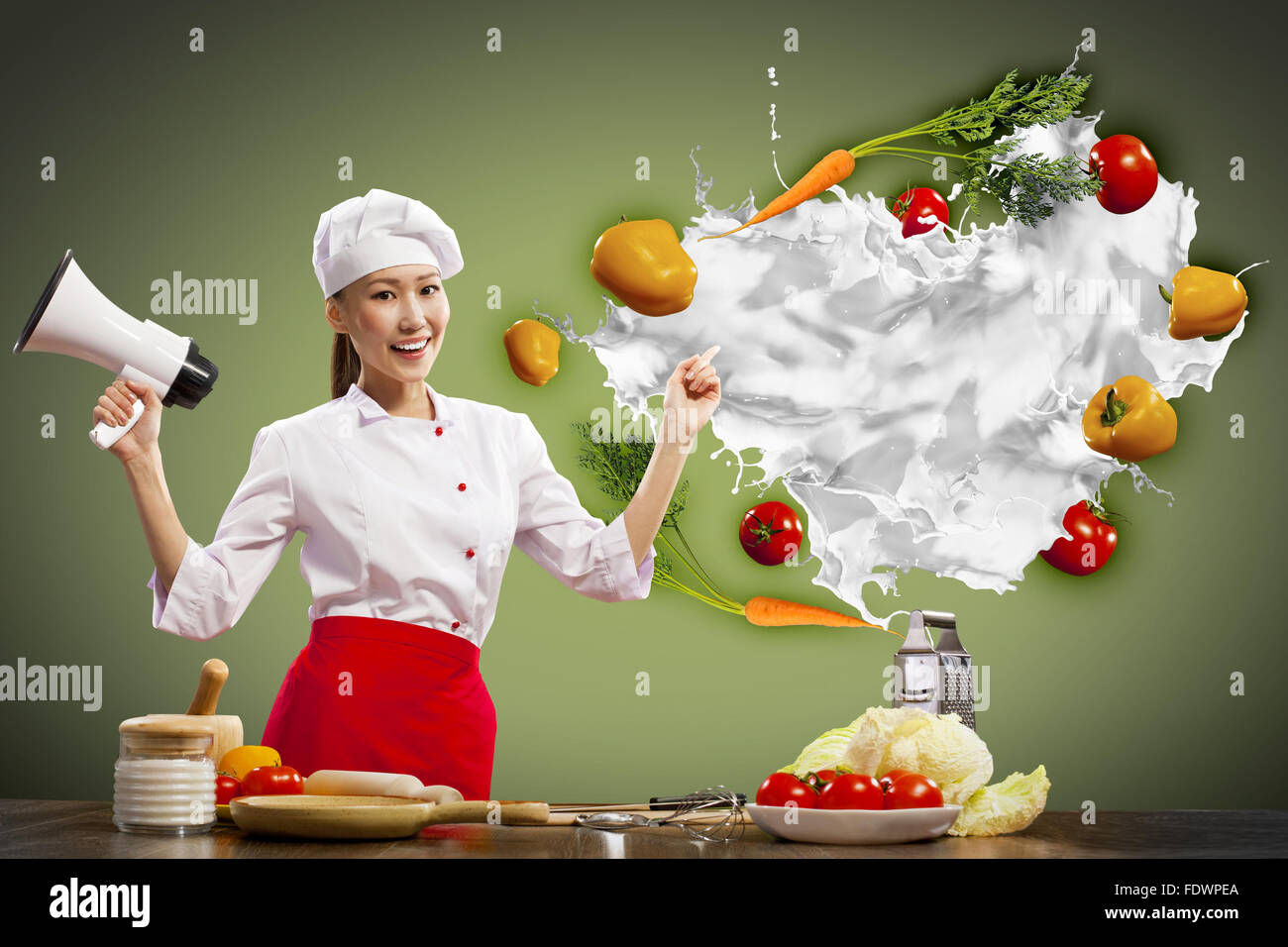 Asian female cook holding megaphone vegetables flying in air Stock ...