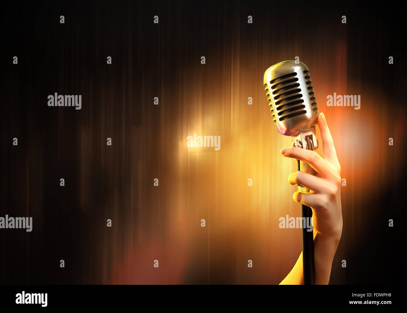 Female hand holding a single retro microphone against colourful ...
