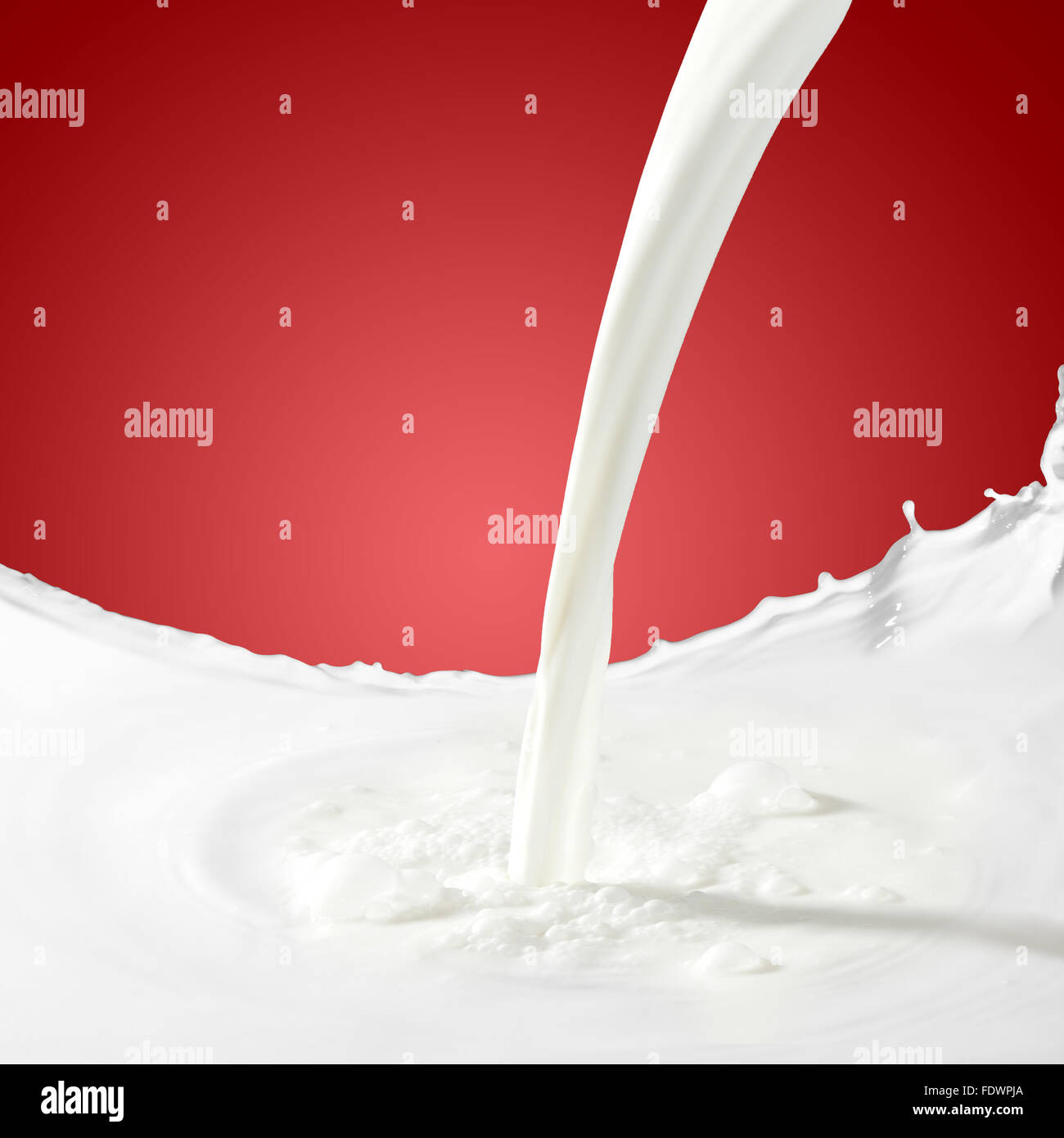 Pouring white milk splash on colour background Stock Photo - Alamy