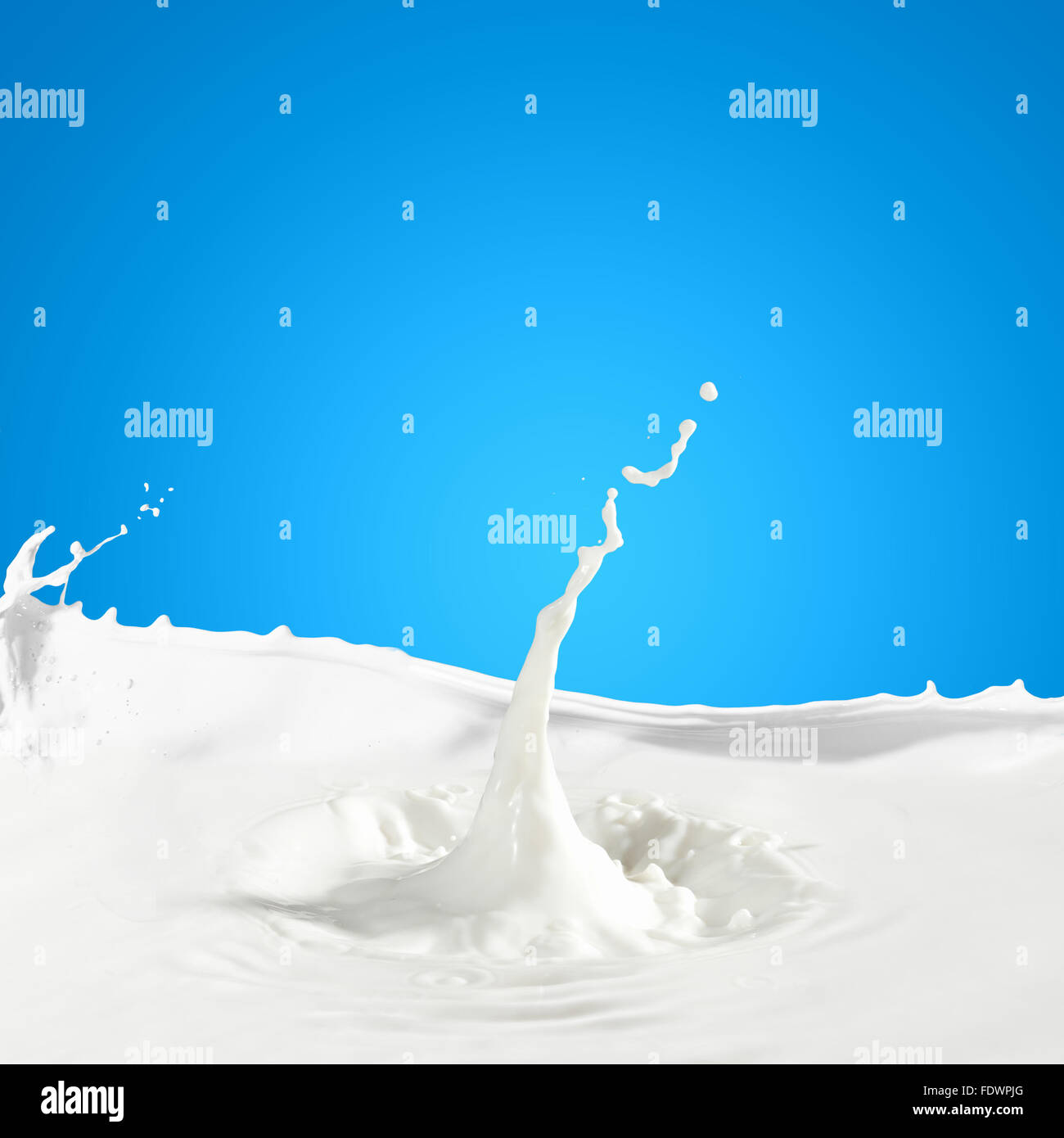 Pouring white milk splash on colour background Stock Photo - Alamy