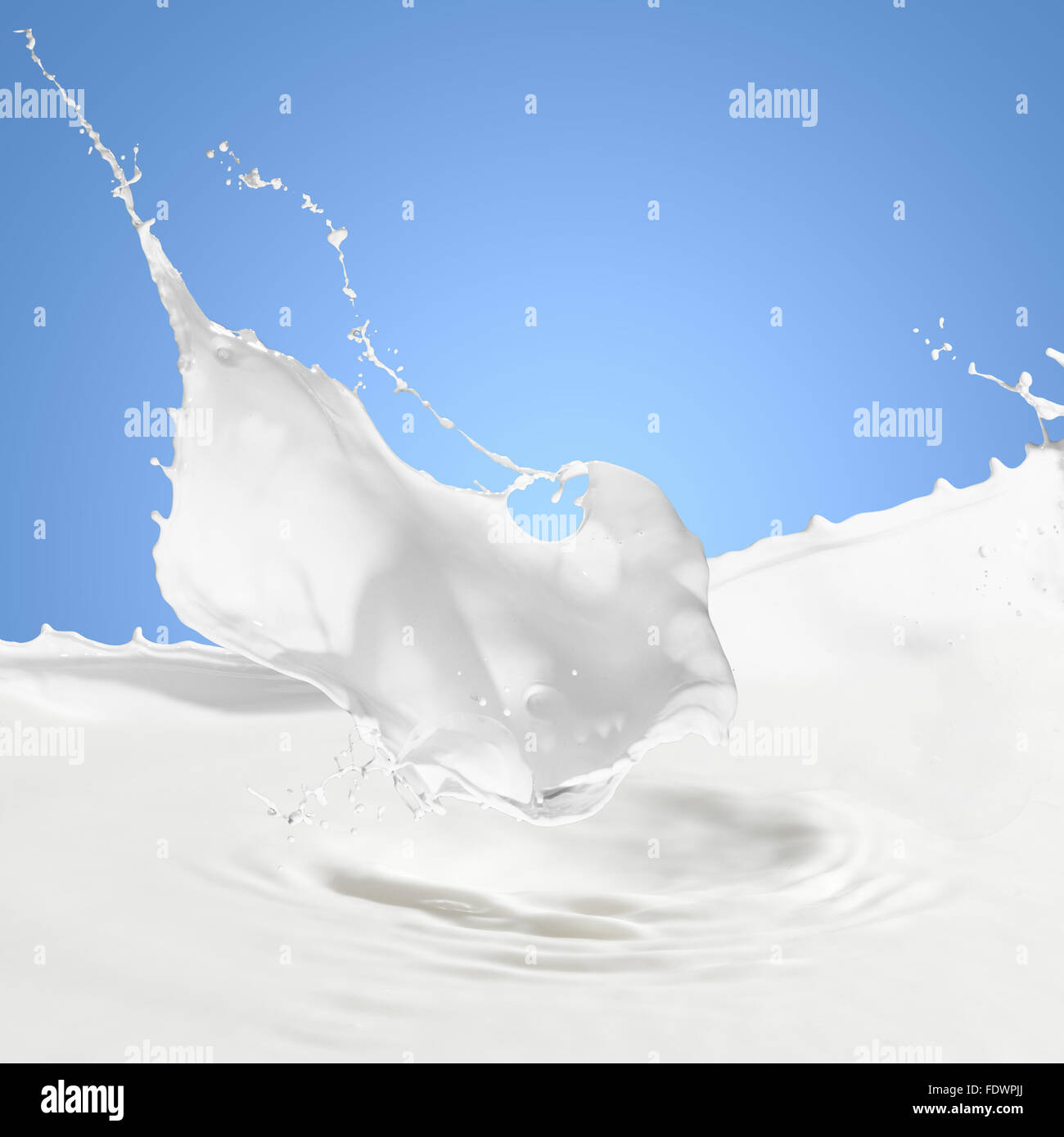 Pouring white milk splash on colour background Stock Photo - Alamy