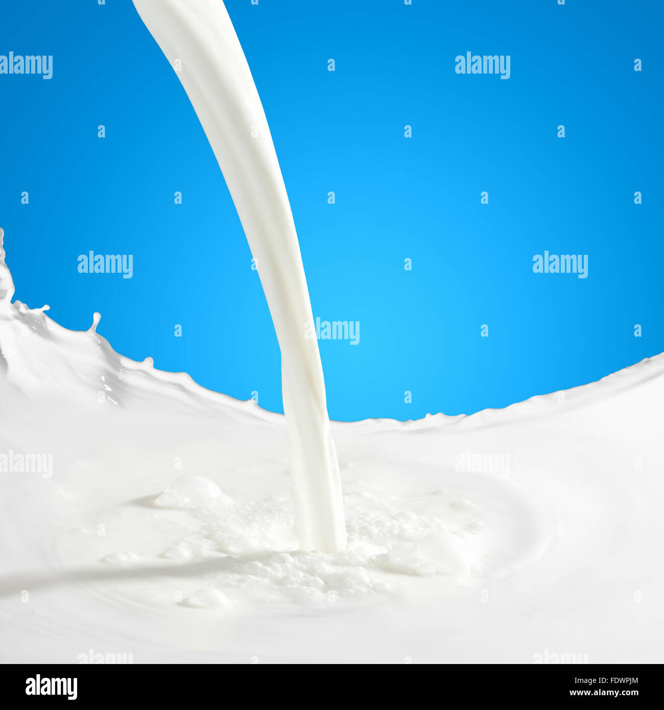 Pouring white milk splash on colour background Stock Photo - Alamy