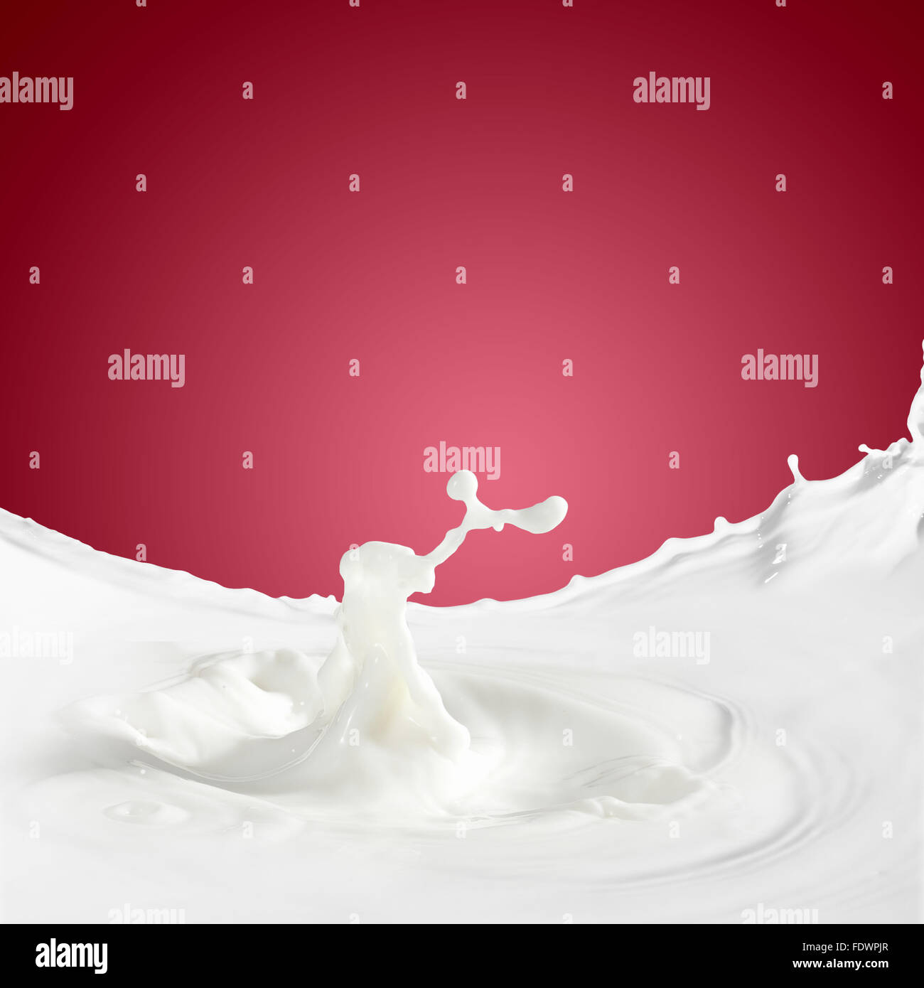 Pouring white milk splash on colour background Stock Photo - Alamy