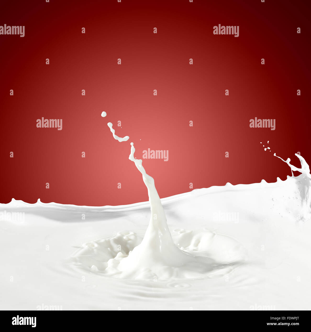 Pouring white milk splash on colour background Stock Photo - Alamy