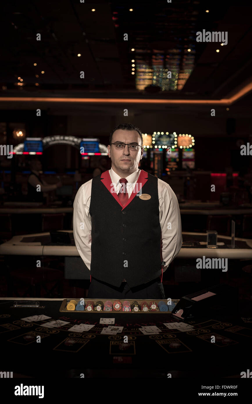 a croupier poses for the camera at a casino ready for people to start ...