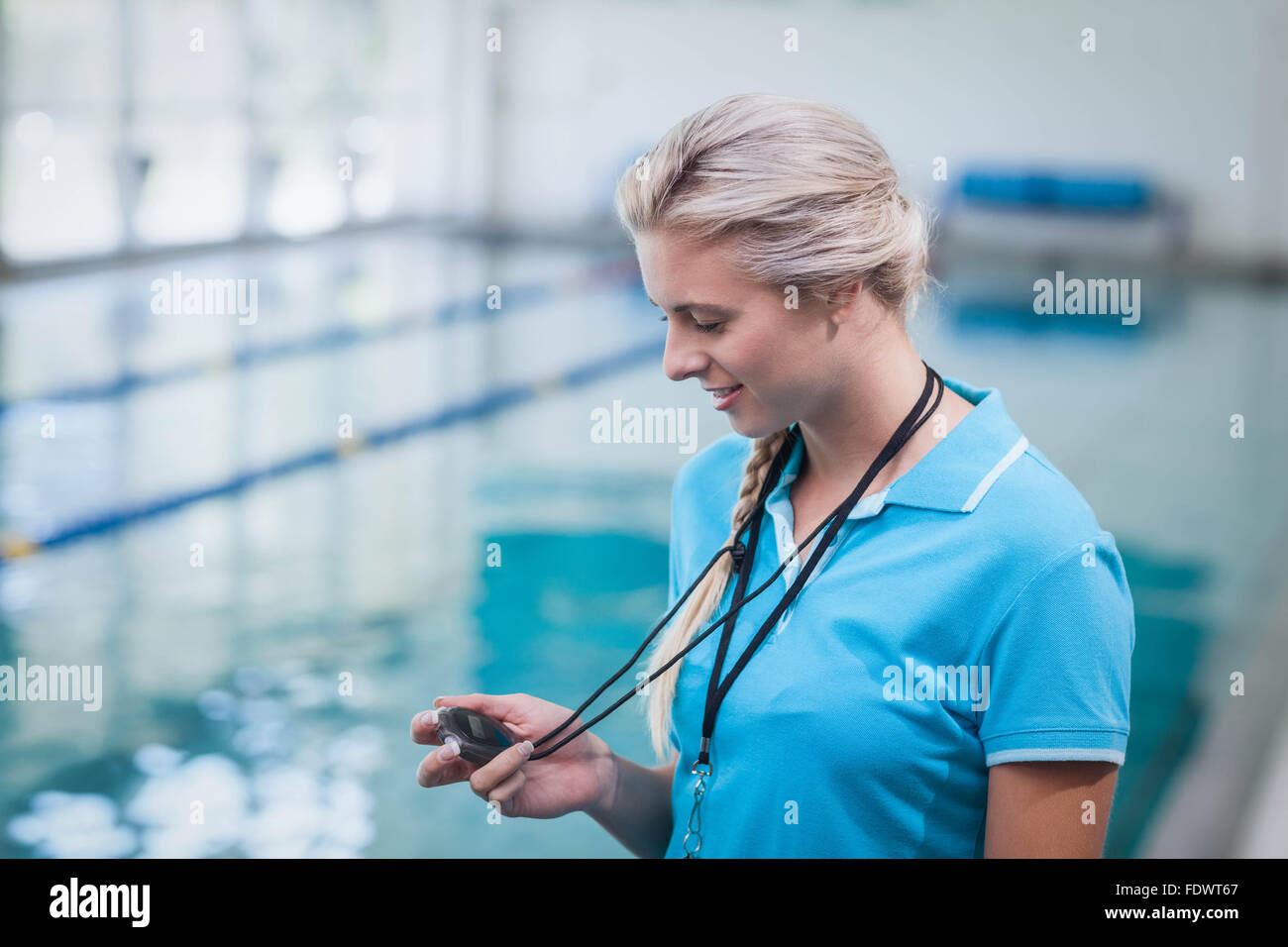 Pretty trainer looking at stopwatch Stock Photo - Alamy